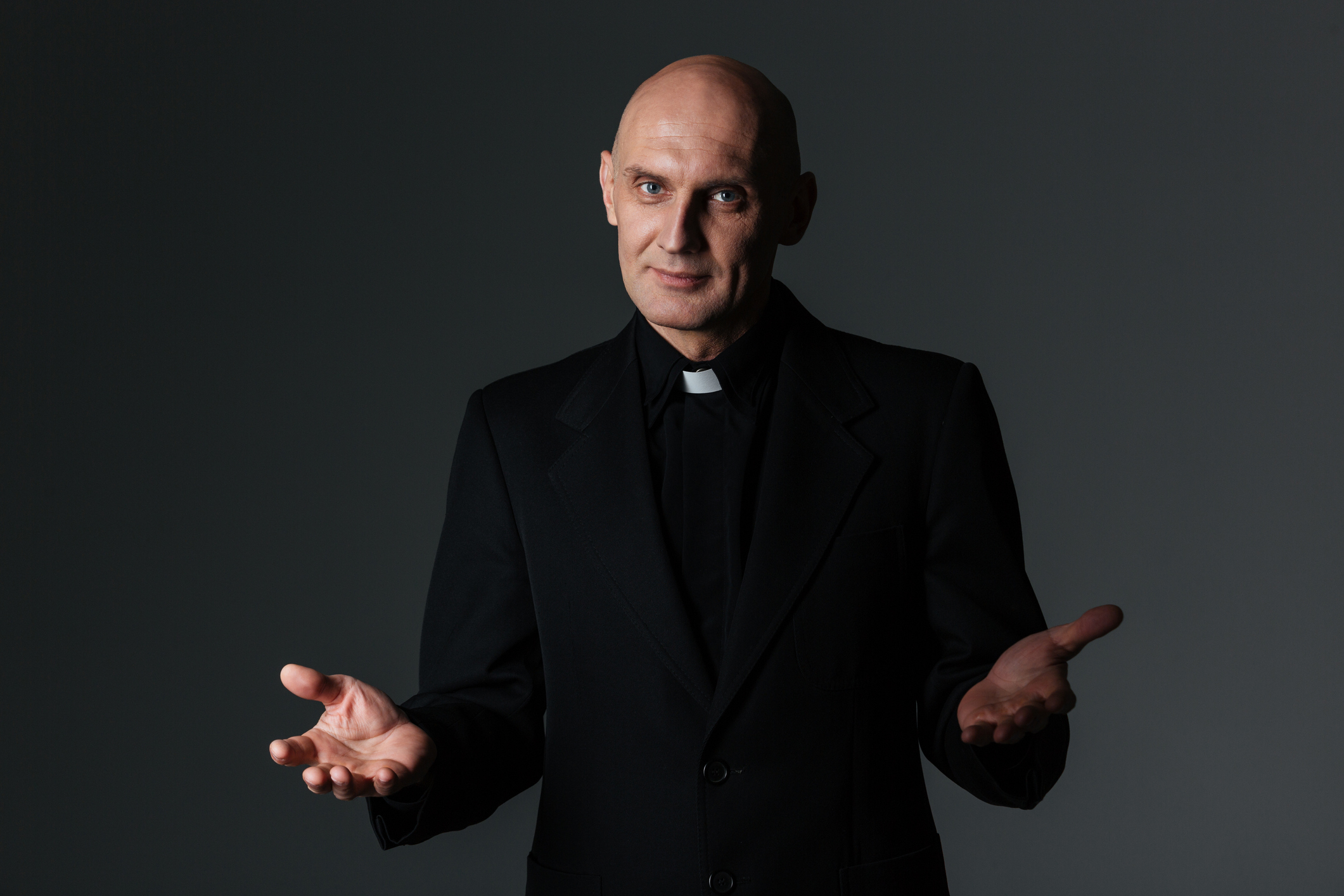 Catholic priest standing and doing welcome gesture | Nova24TV